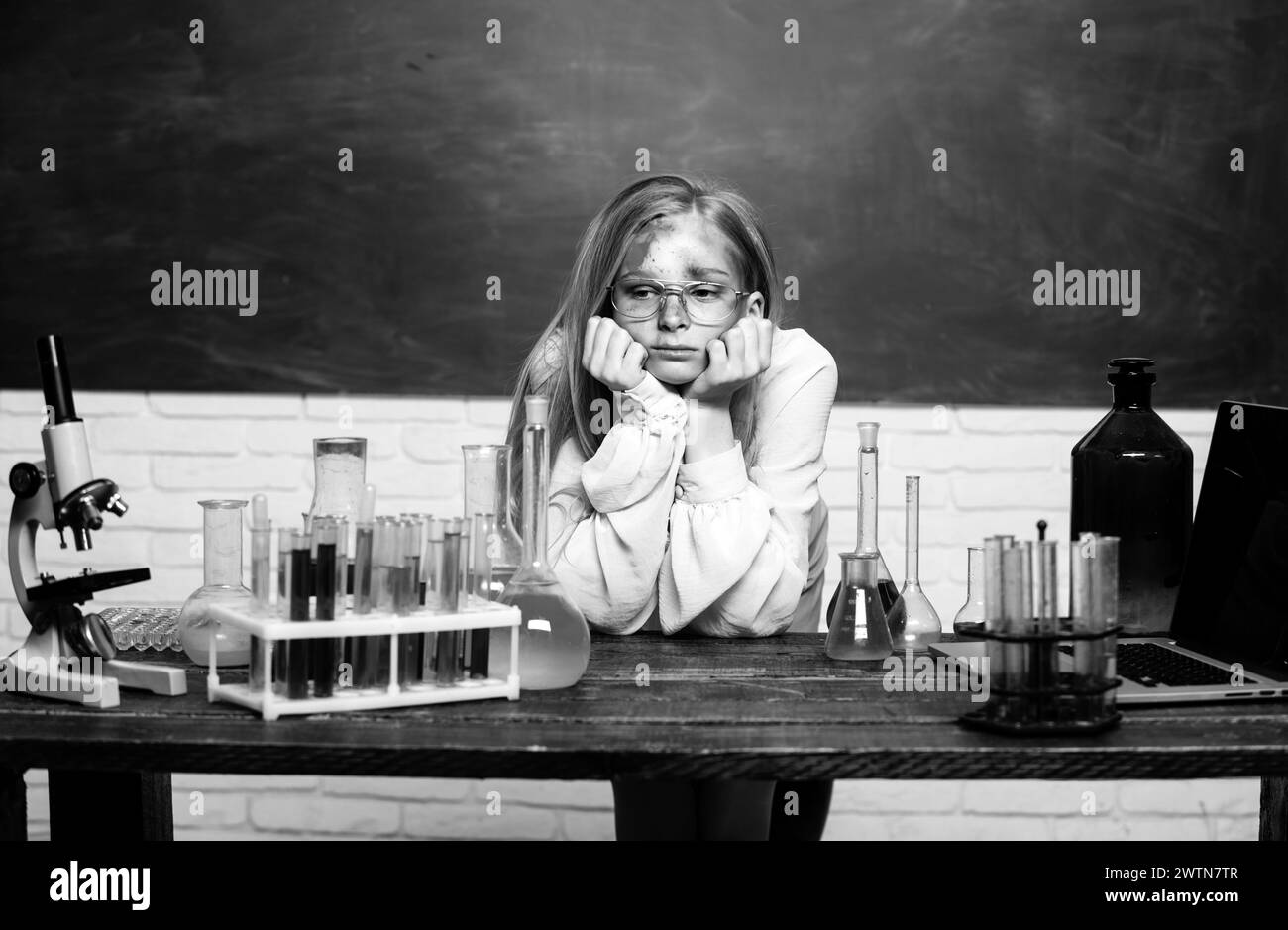 Funny sad schoolgirl scientist in the laboratory. Chemical experiment ...