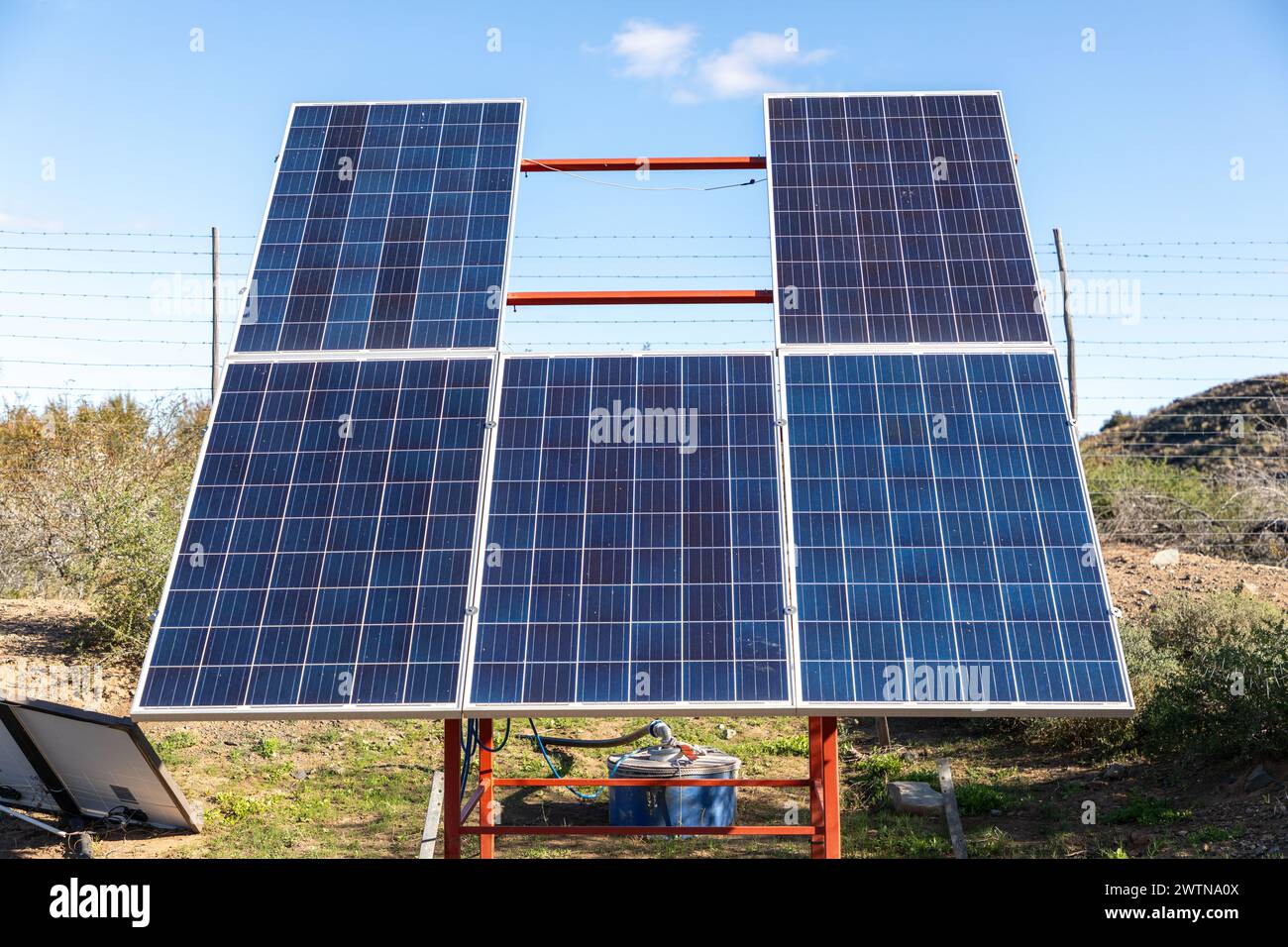 Solar panels, with one panel missing, on a metal frame with a borehole ...