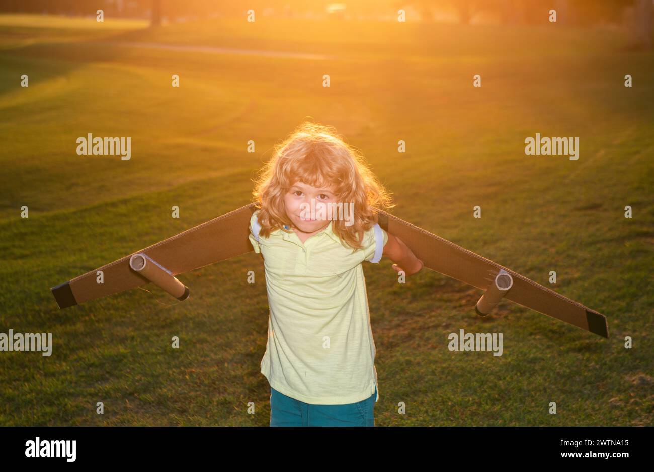Child playing with toy jetpack at sunset grass field. Child pilot ...