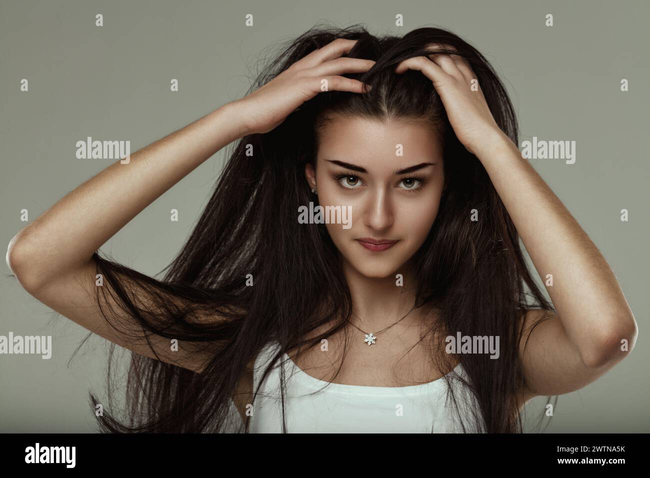 Confident, mysterious look as she runs fingers through hair Stock Photo ...