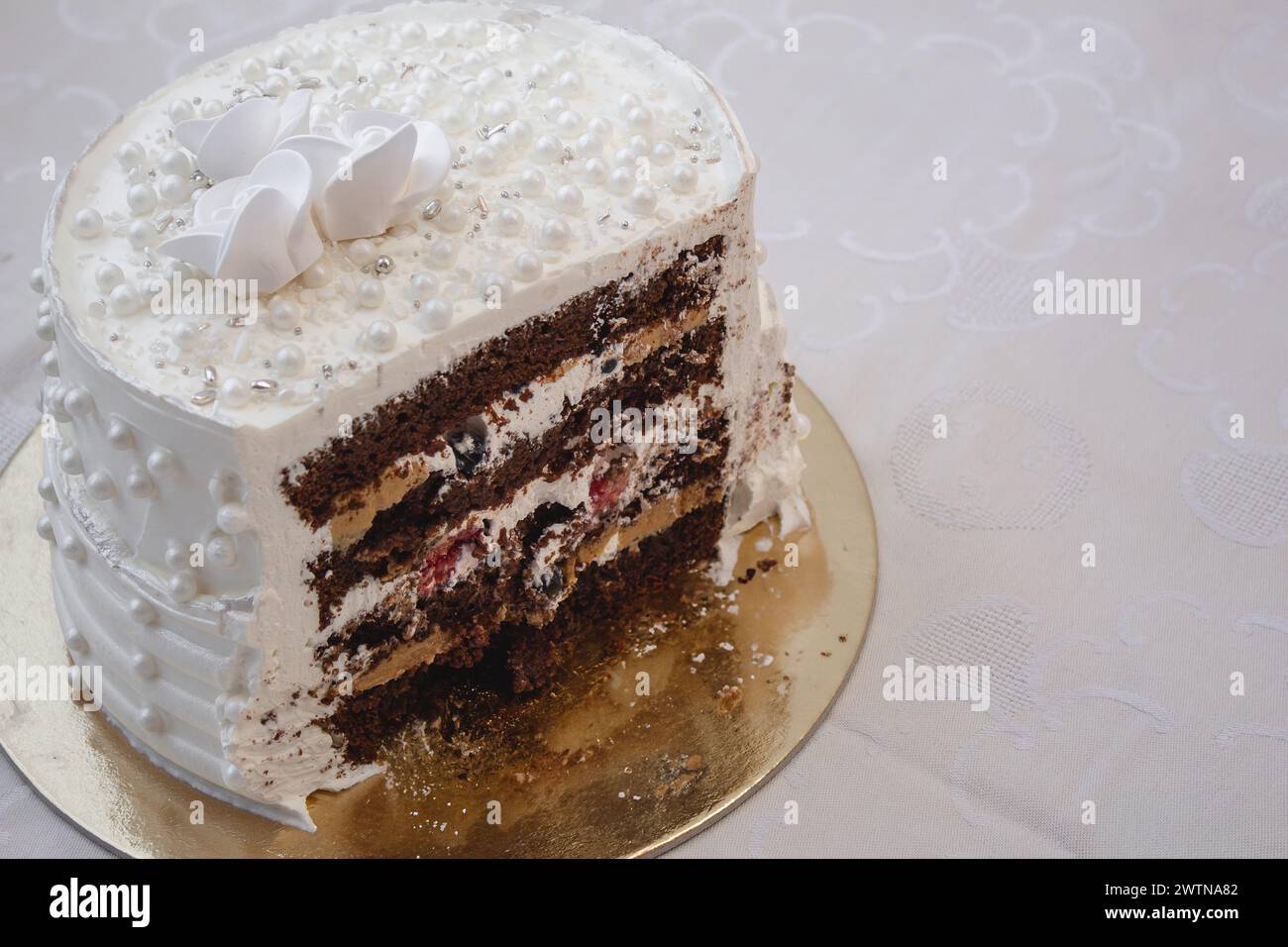 White party cake with pearls and white icing and red fruit and ...