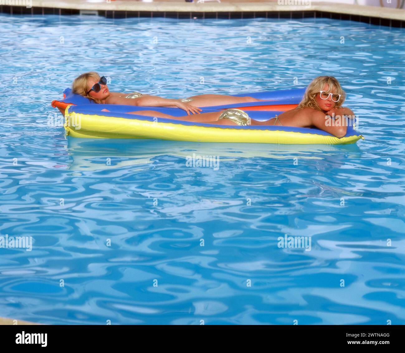 Mallorca. Santa Ponsa. Two young women in swimwear floating on airbed in hotel pool Stock Photo ...