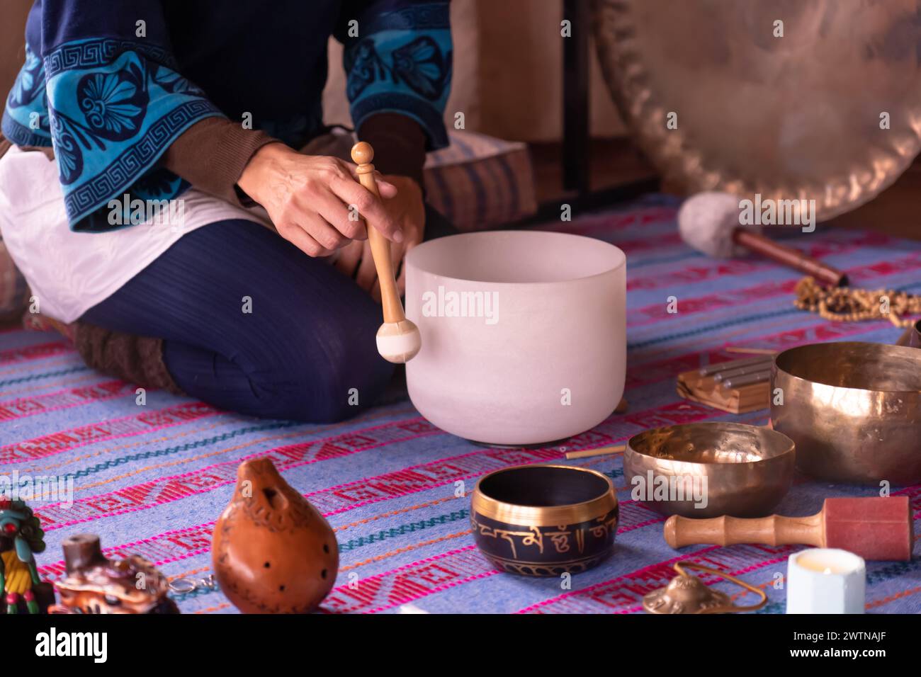 Close-up of a woman's hands playing a quartz singing bowl, while ...