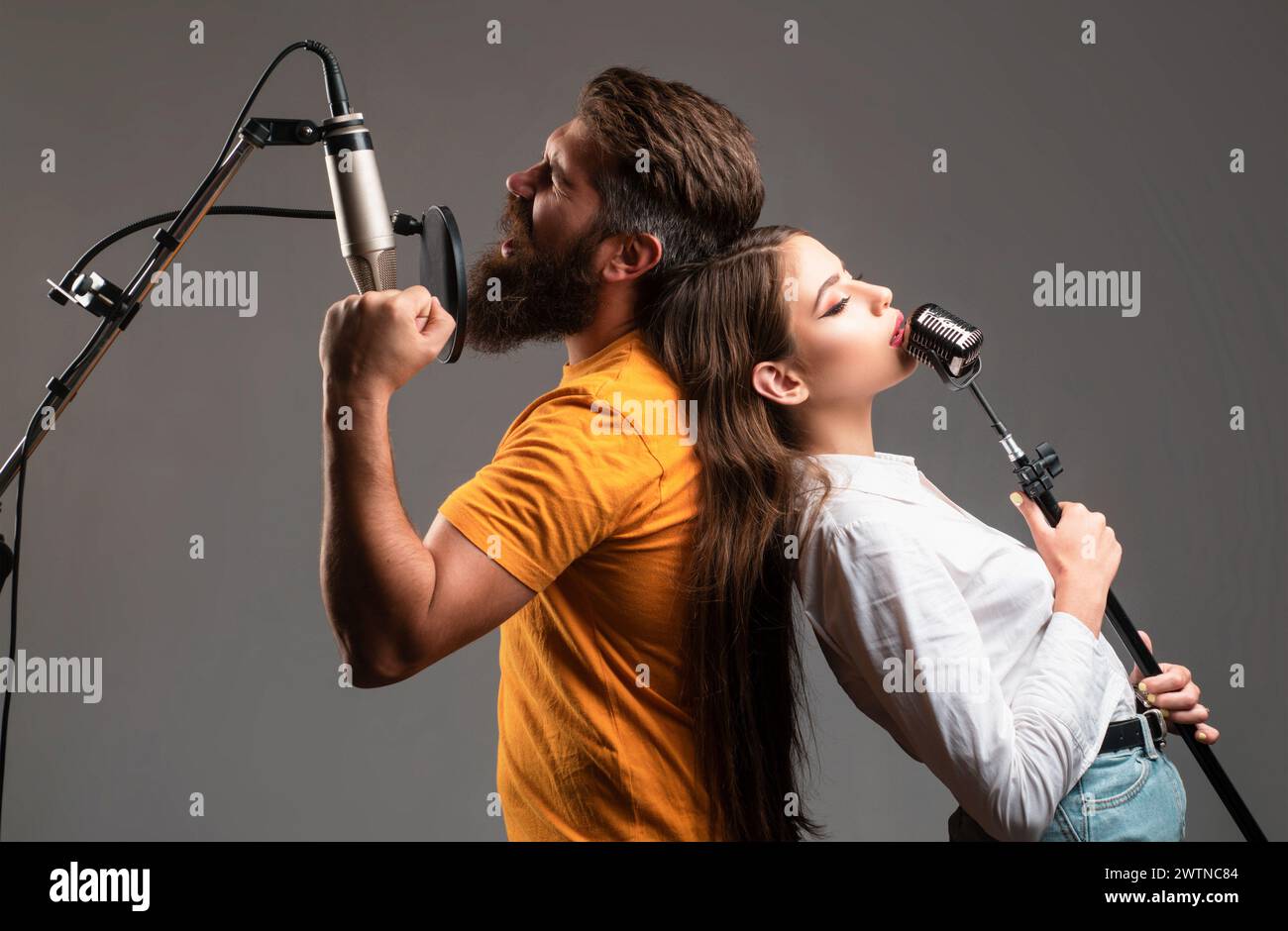 Boy and girl with excited faces enjoy music. Couple in recording studio ...