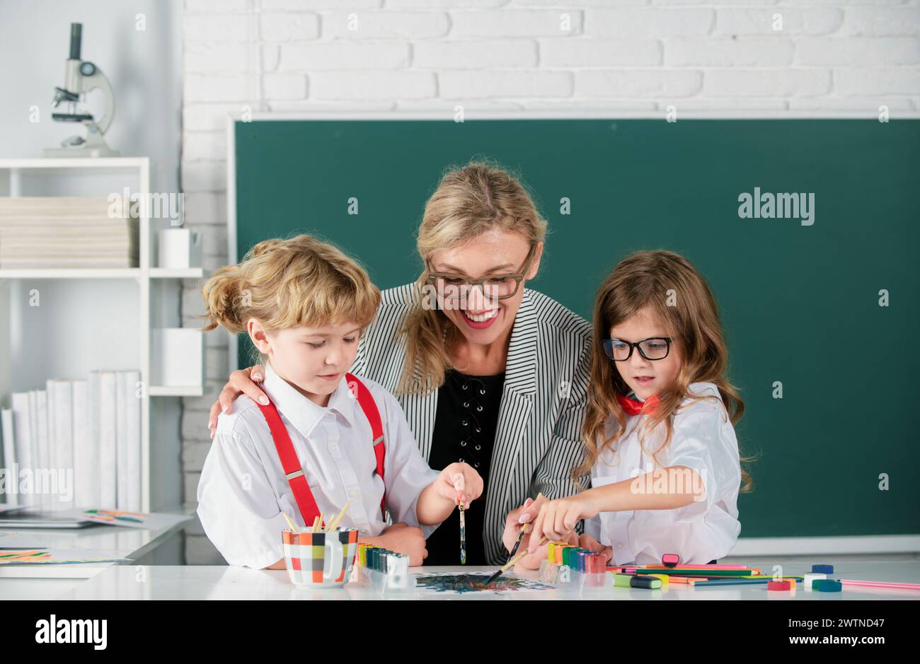 Schoolkids with teacher. Happy children from elementary school study at ...