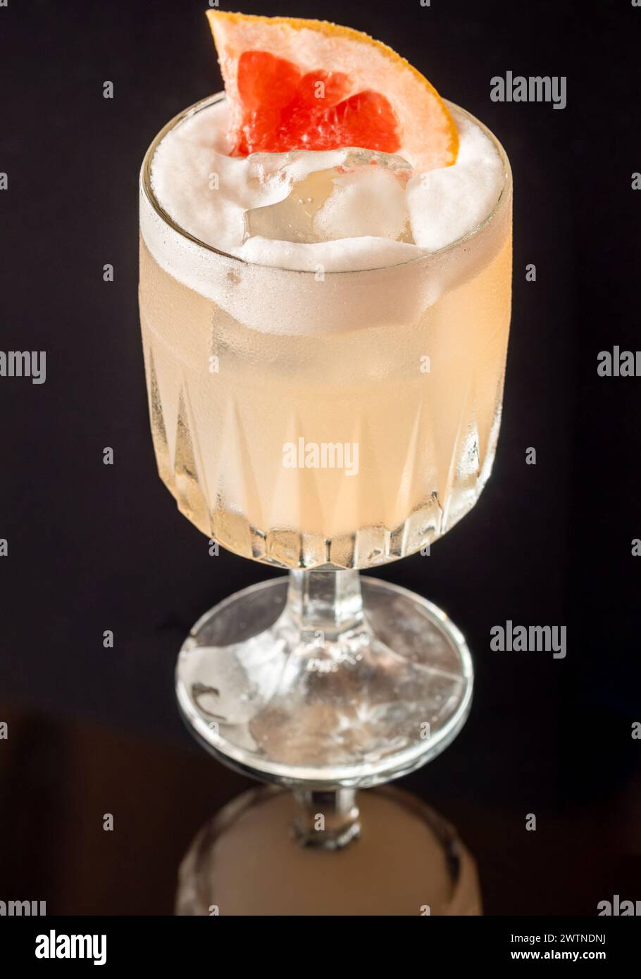Goblet glass of Grapefruit tequila sour cocktail Stock Photo - Alamy
