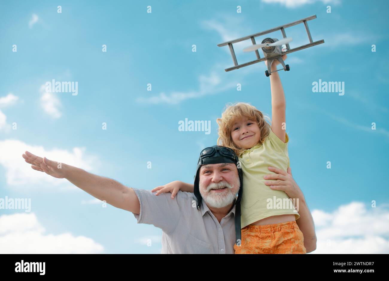 Grandfather and son having fun with plane outdoor on sky background ...