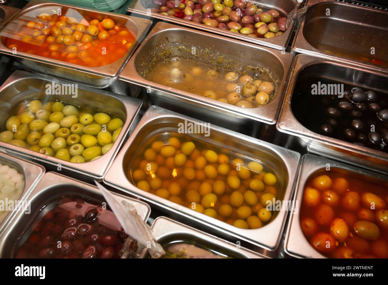 Containers full of olives and pickles. Window display of a shop selling ...