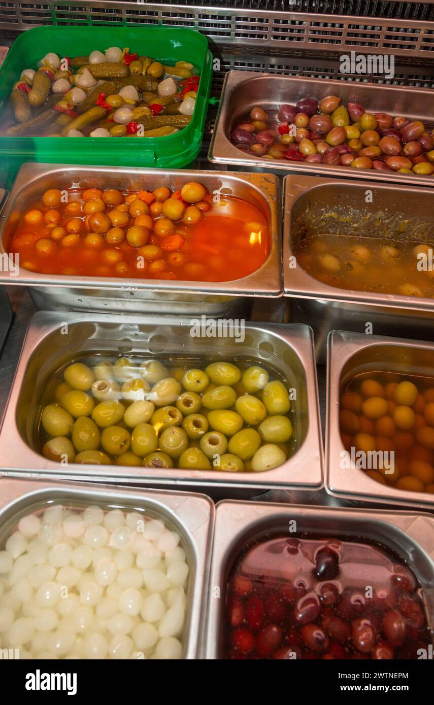 Containers full of olives and pickles. Window display of a shop selling ...