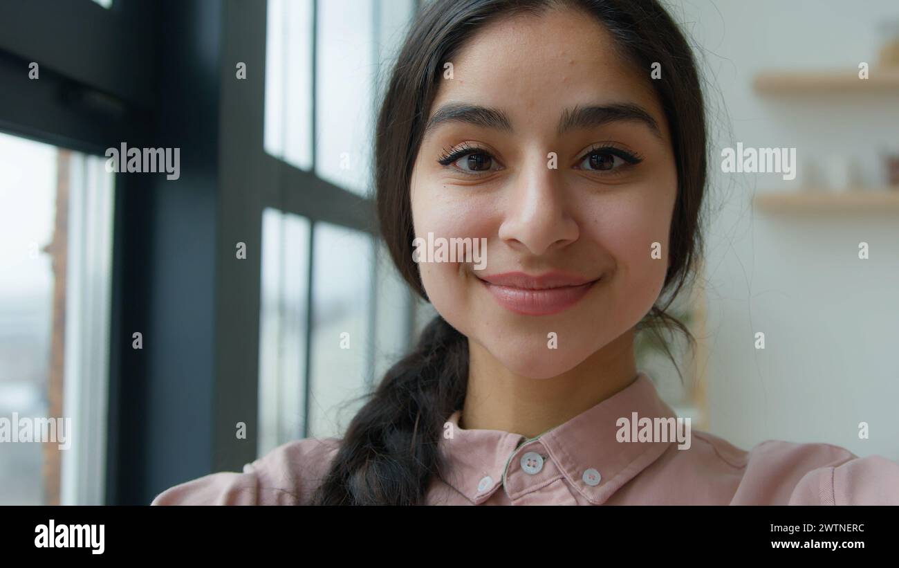 Headshot happy Arabian Indian ethnic millennial woman student girl businesswoman near window ...