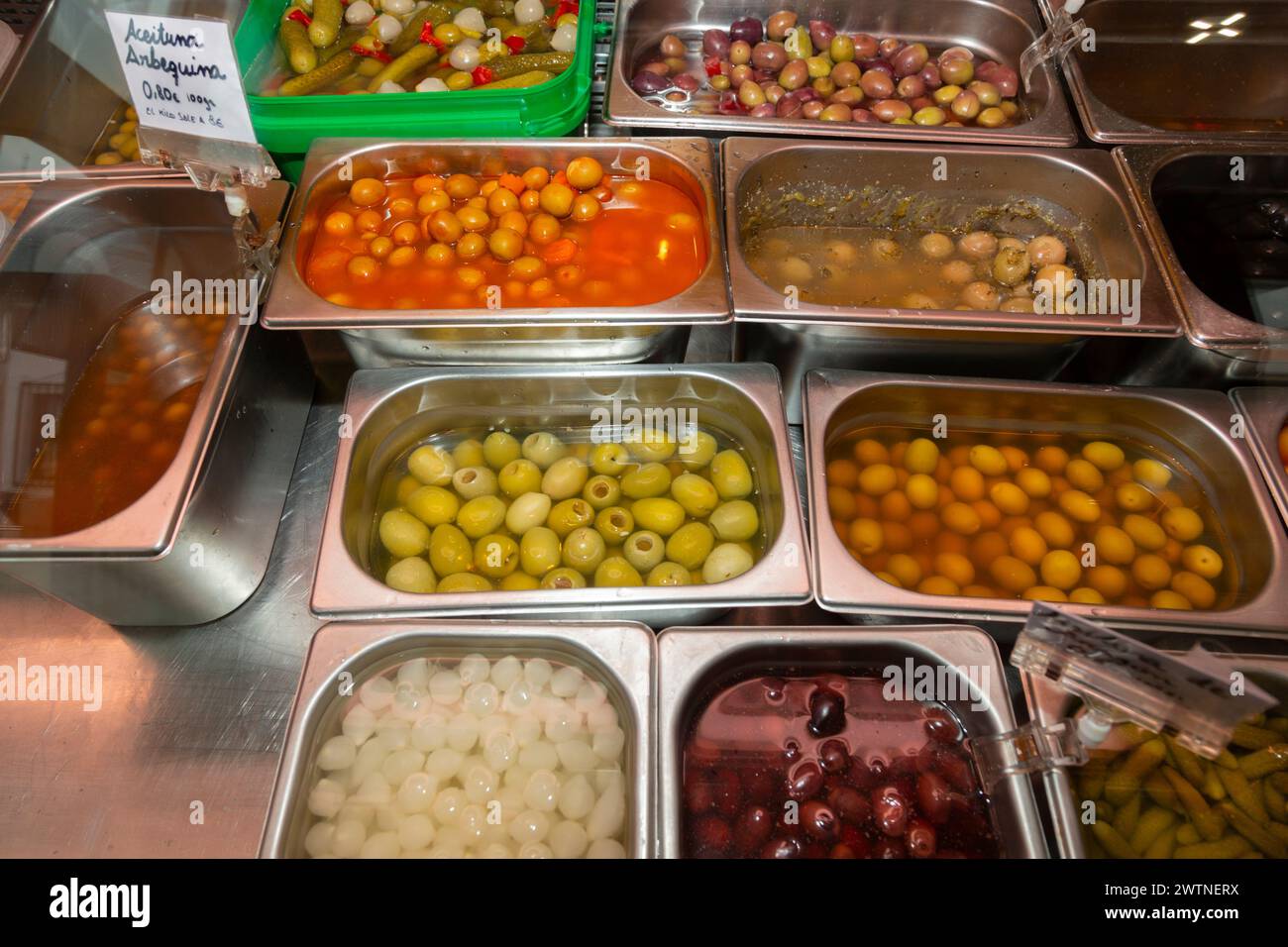 Containers full of olives and pickles. Window display of a shop selling ...