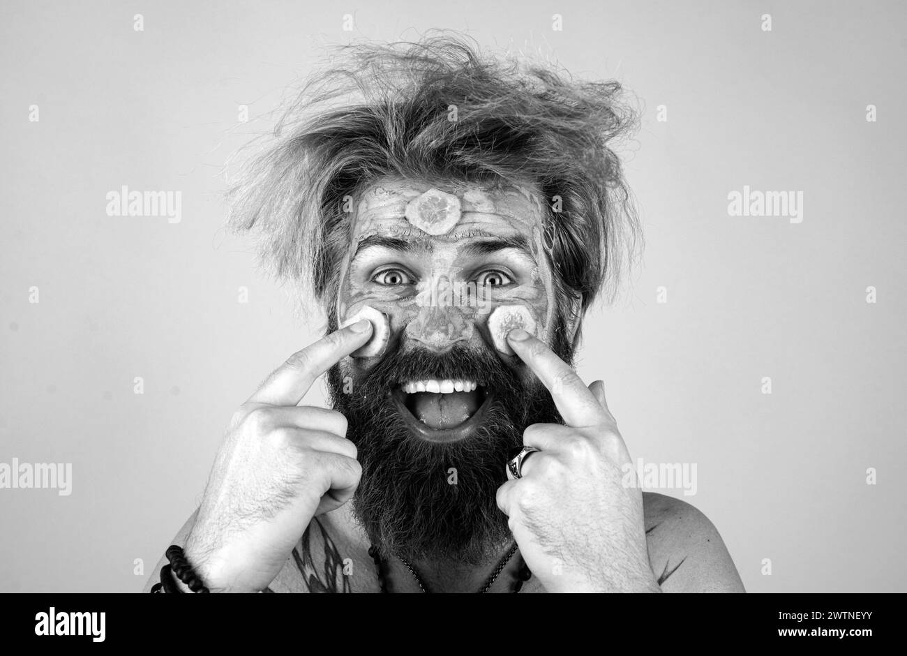 Funny man face with clay mask and cucumber slices. Spa, dermatology ...