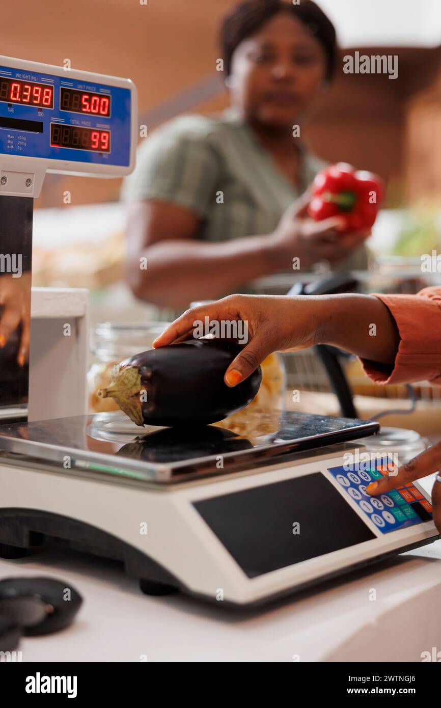 At the counter, an African American cashier weighs locally grown ...
