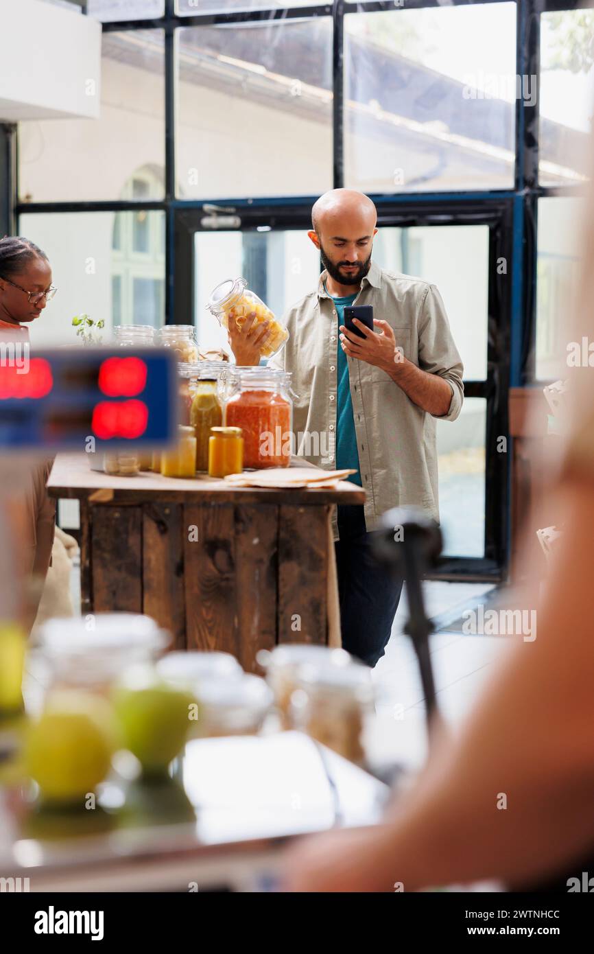 Arab male customer concentrating on his mobile device while clutching ...