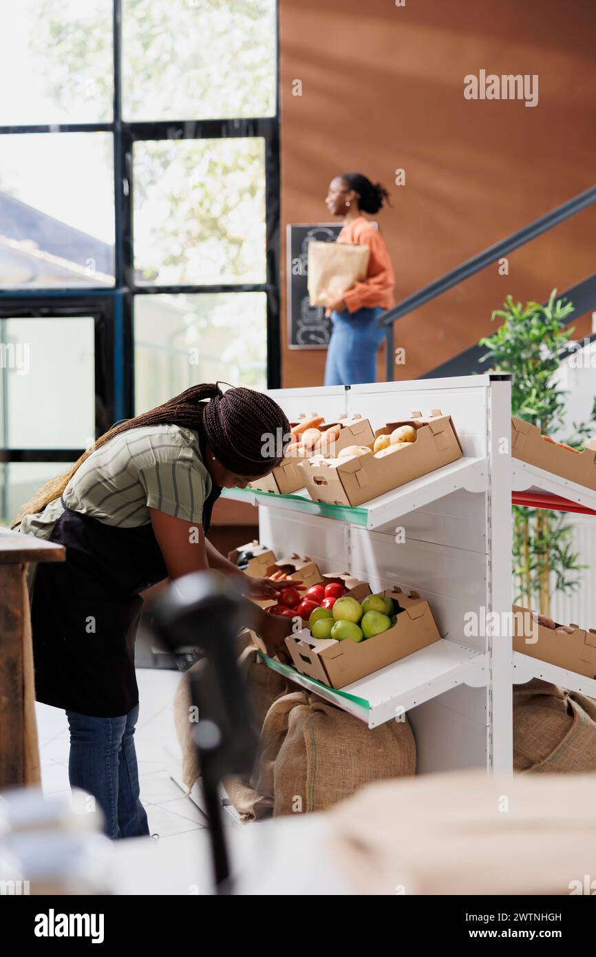 In bio food market, female seller wearing an apron organizes homegrown ...