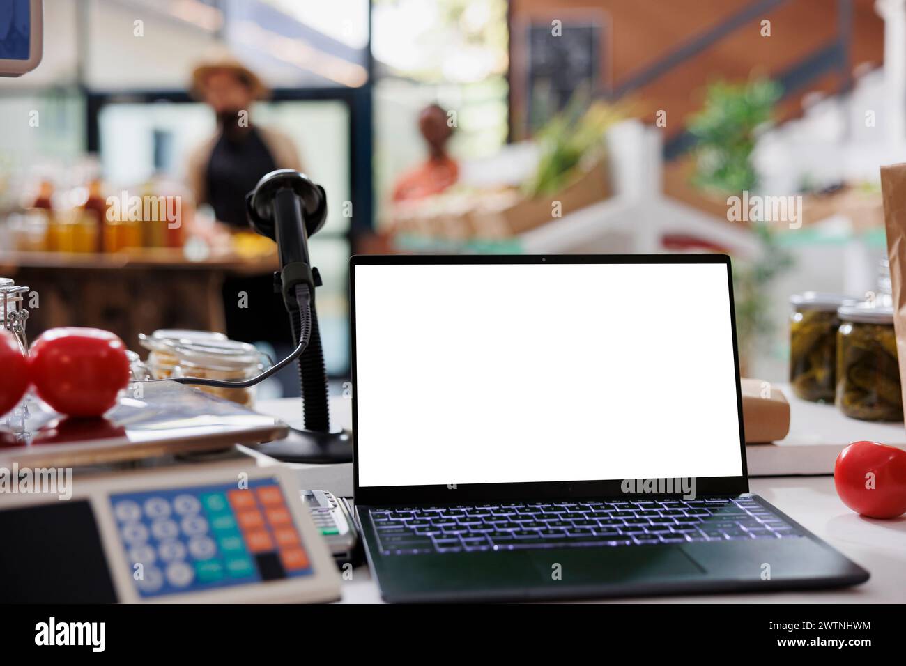 Black laptop with blank white screen placed on a counter next to a ...