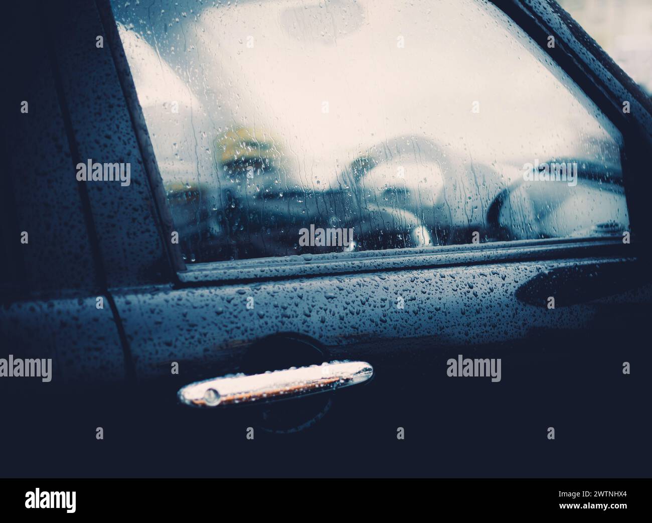 A photo of a car, wet from the heavy rain. The raindrops are running ...