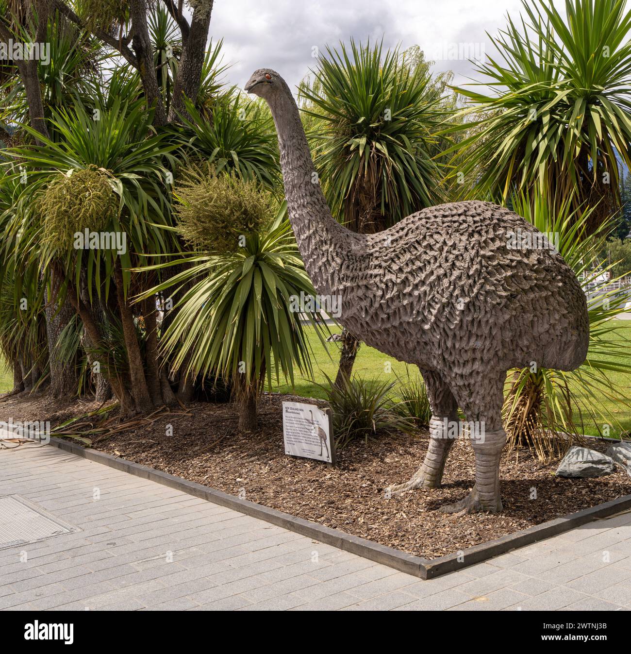 Life-size Moa bird carved wooden cstatue amidst lush greenery in ...