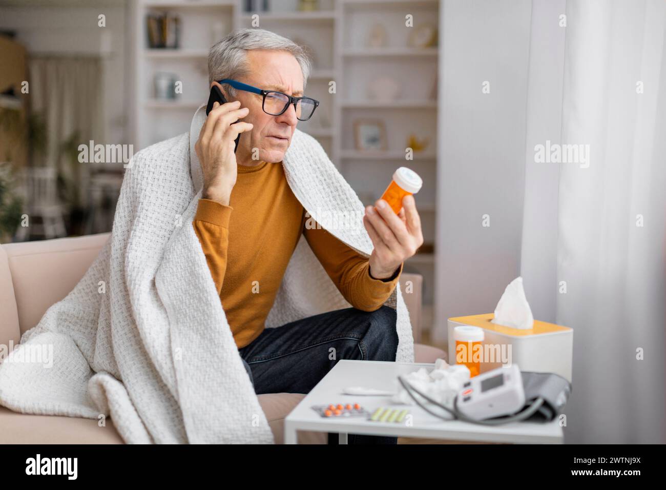 Older man examining medication with square cover Stock Photo - Alamy