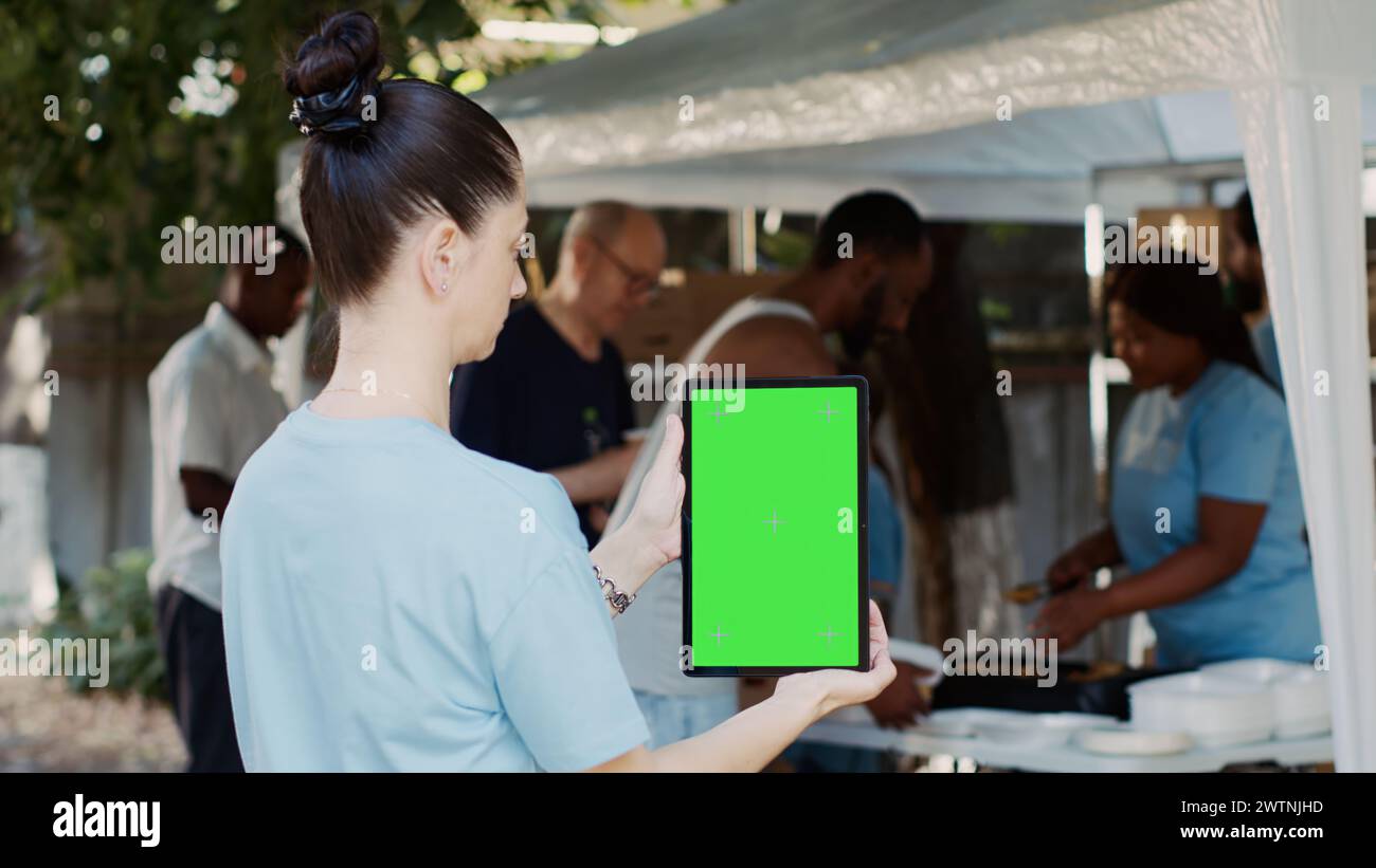 Caucasian lady holding smart tablet with a chromakey mockup template ...