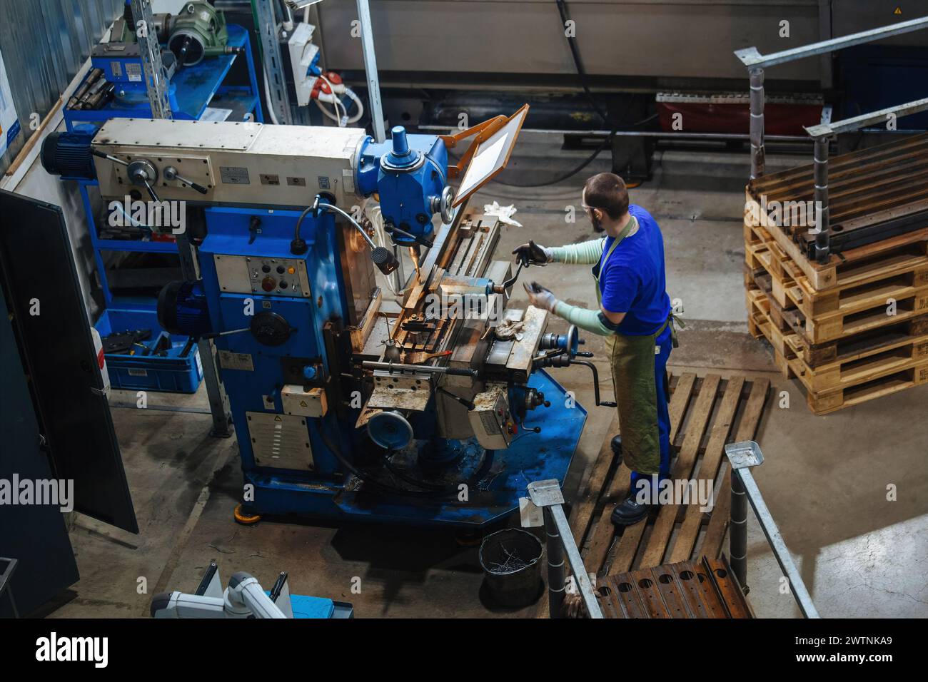 Industrial worker operating drilling machine Stock Photo - Alamy