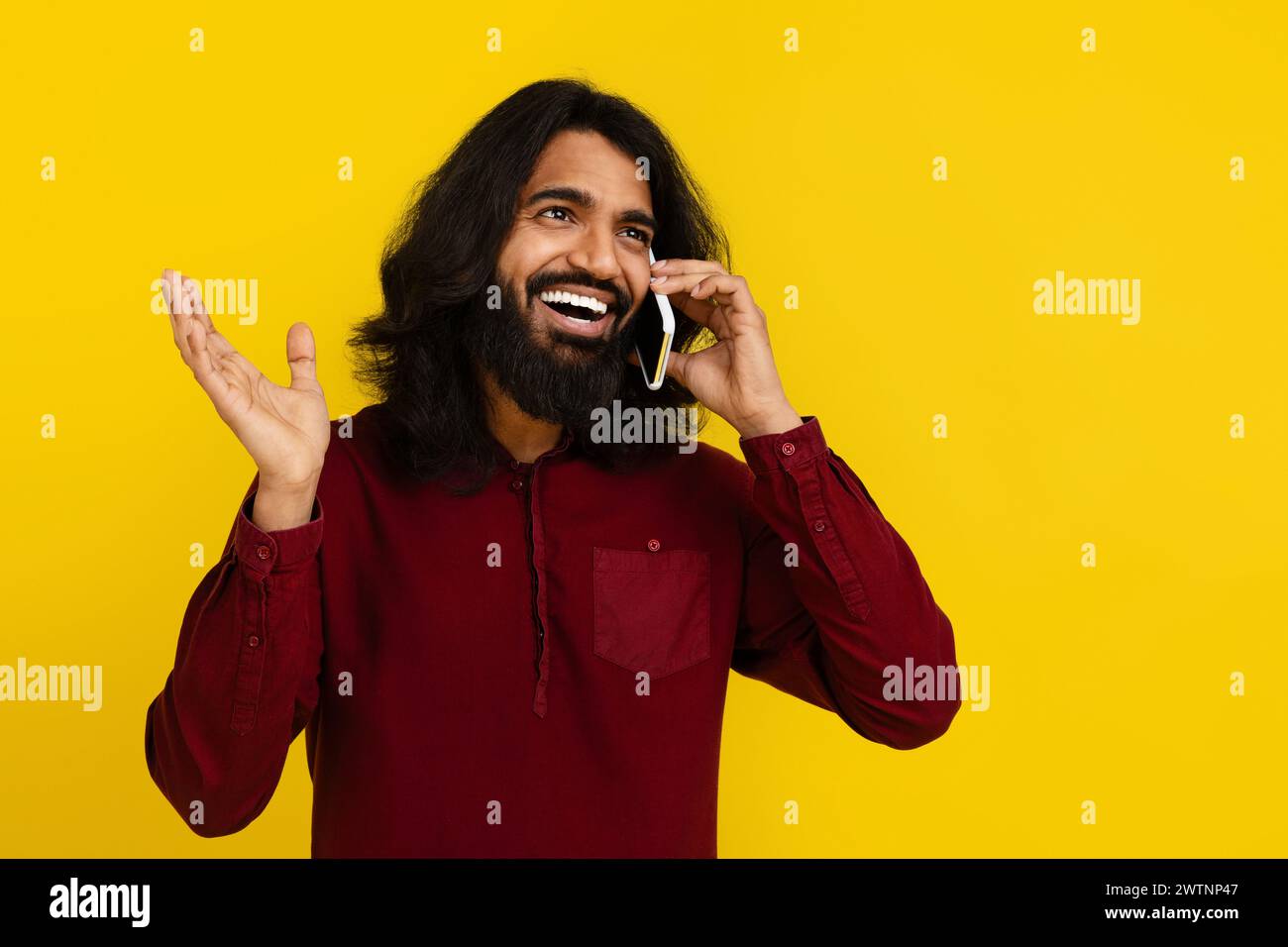 Happy indian guy have phone conversation on yellow background Stock ...