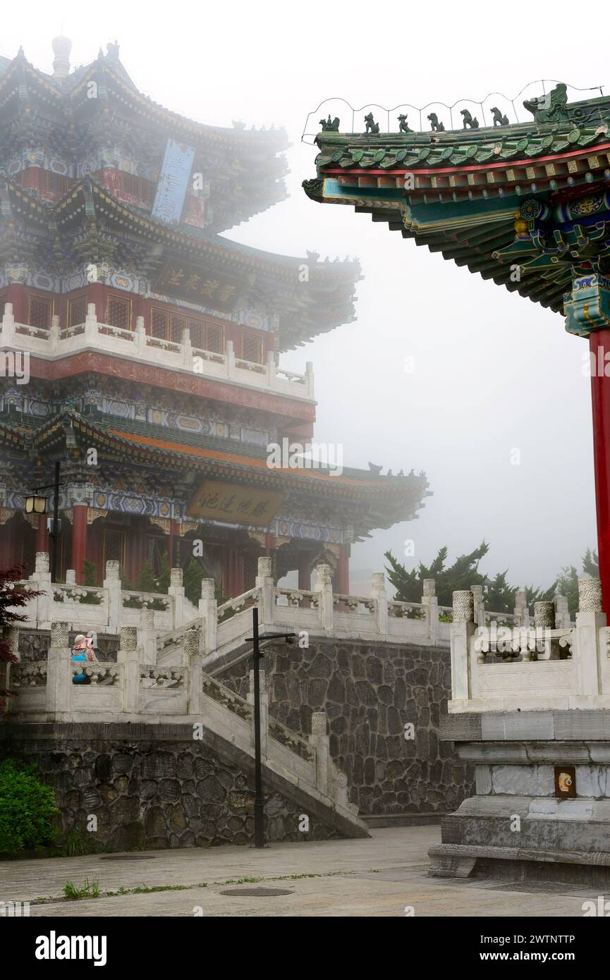 A break in fog reveals the Buddhist Men Shan Temple in Tianmen Mountain ...