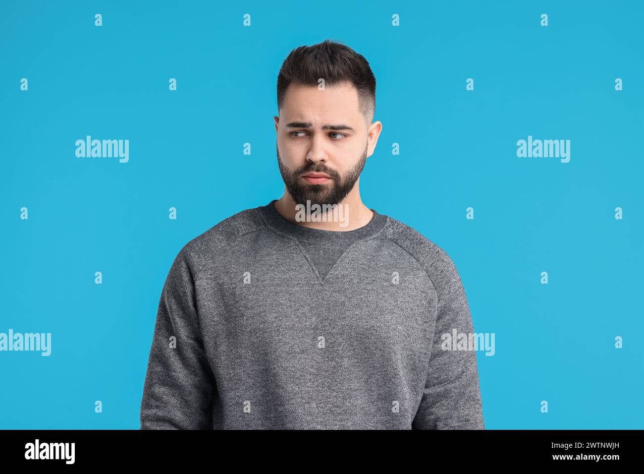 Portrait of sad man on light blue background Stock Photo - Alamy