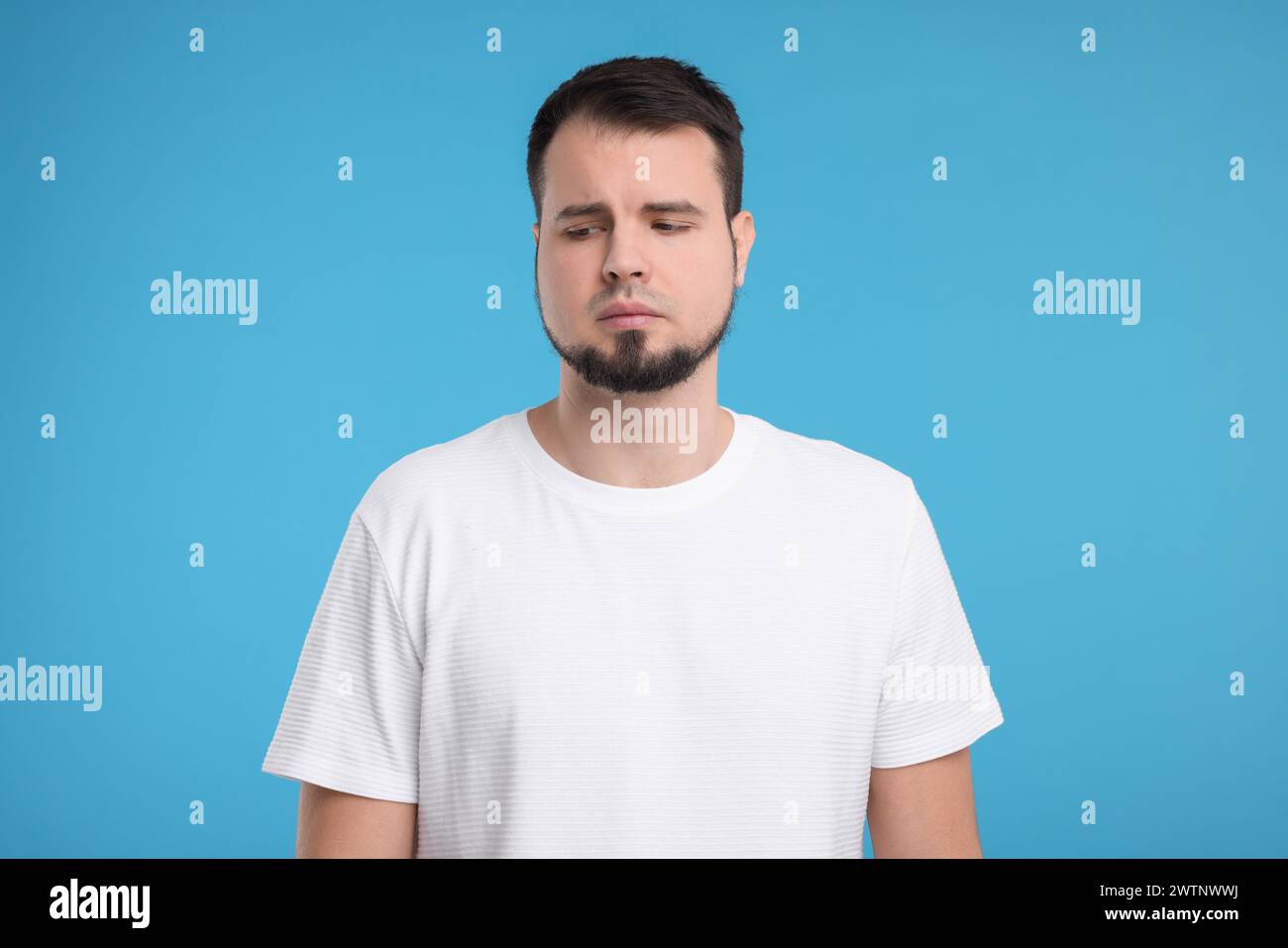 Portrait of sad man on light blue background Stock Photo - Alamy