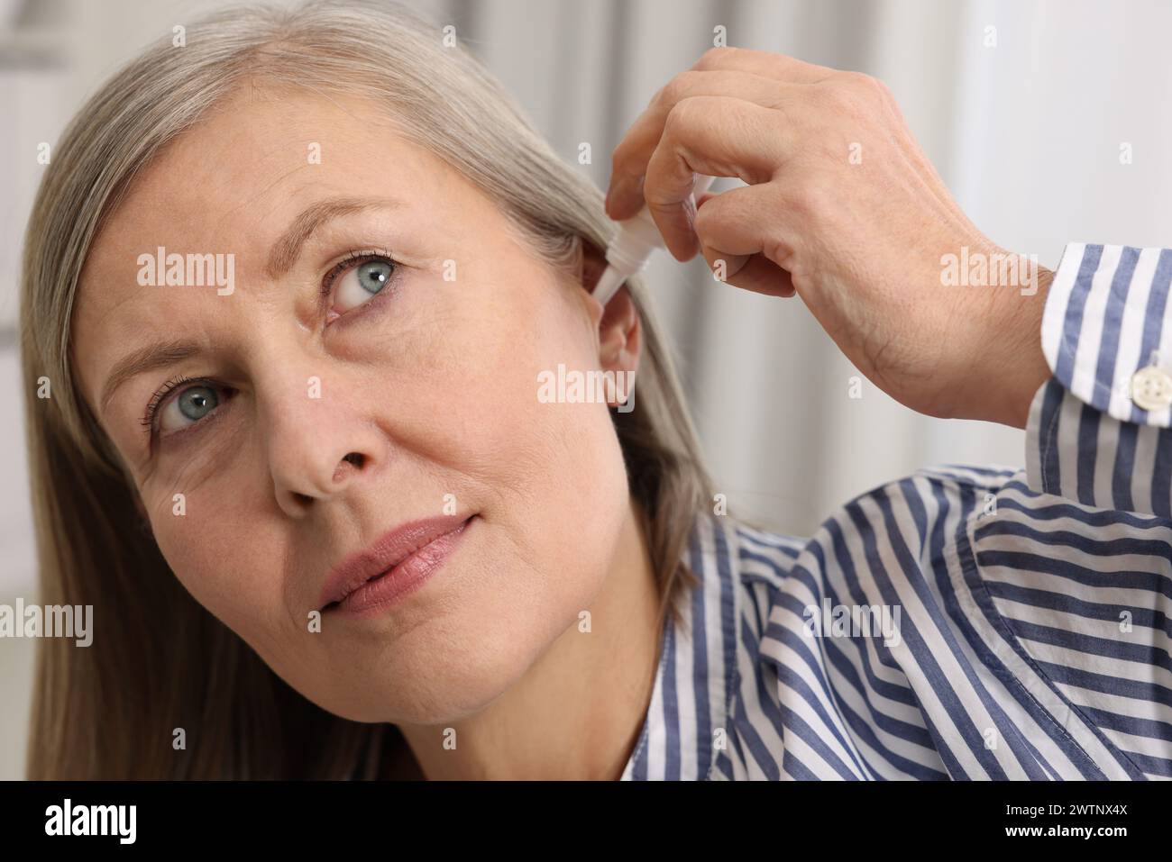 Woman applying medical ear drops at home Stock Photo - Alamy