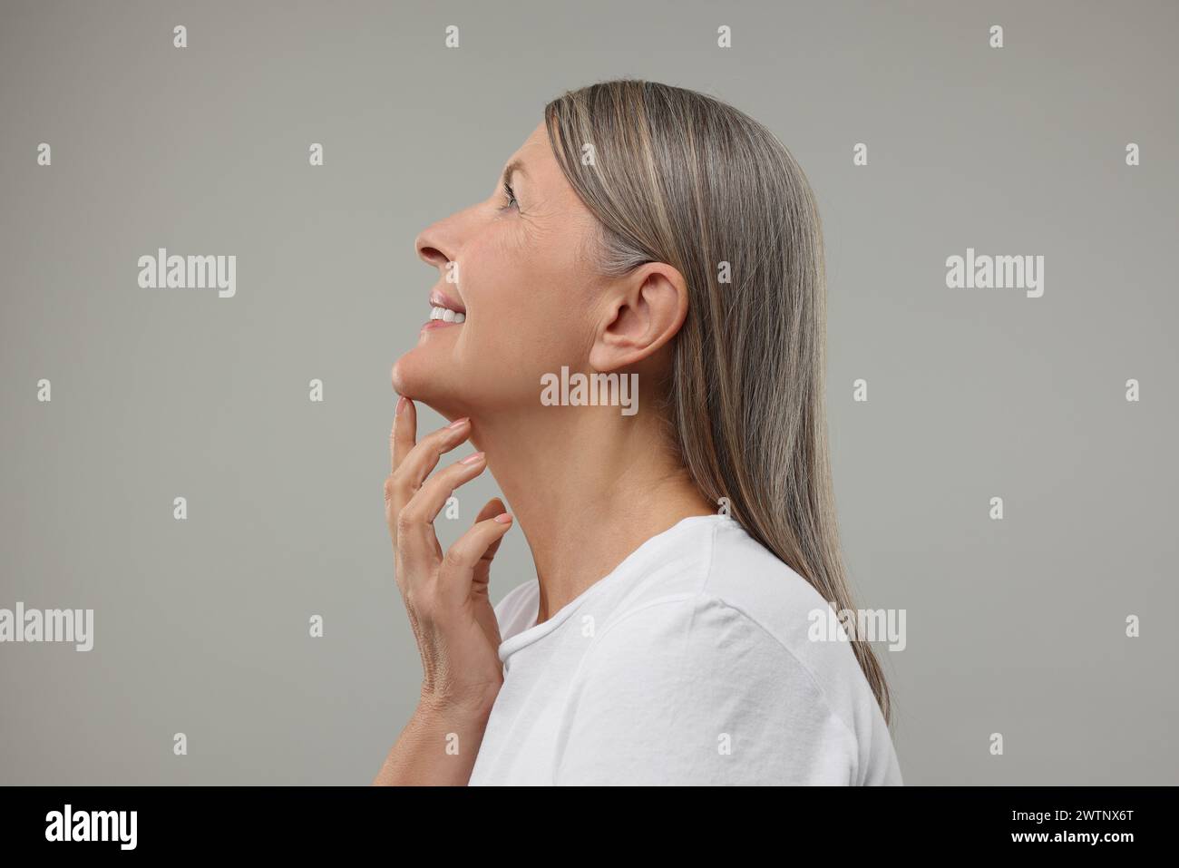 Beautiful woman with healthy skin on grey background Stock Photo - Alamy