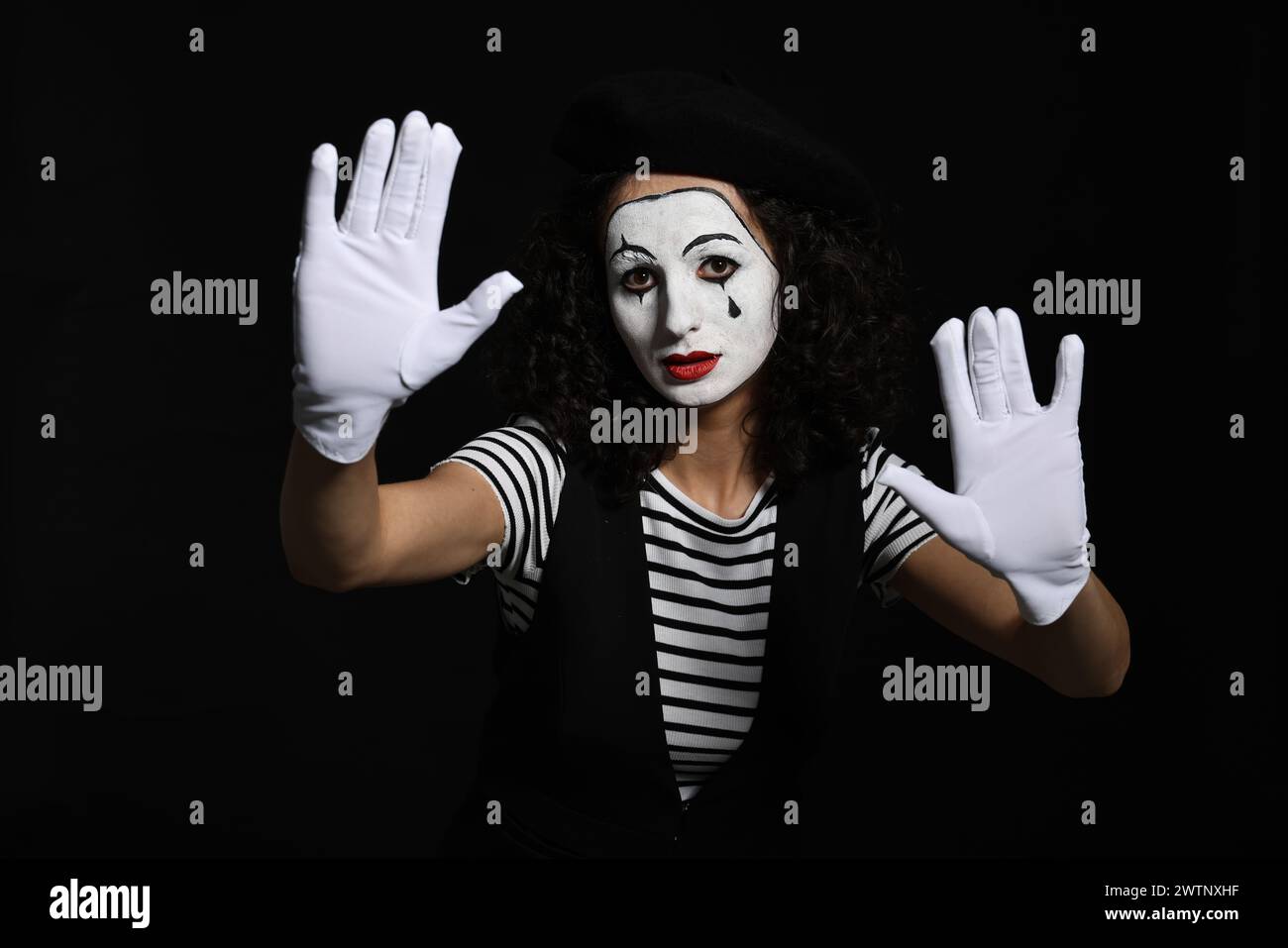 Young woman in mime costume posing on black background Stock Photo - Alamy