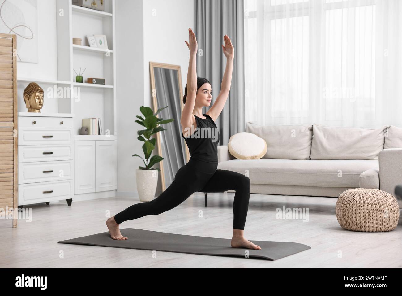Girl practicing crescent asana on yoga mat at home. High lunge pose ...