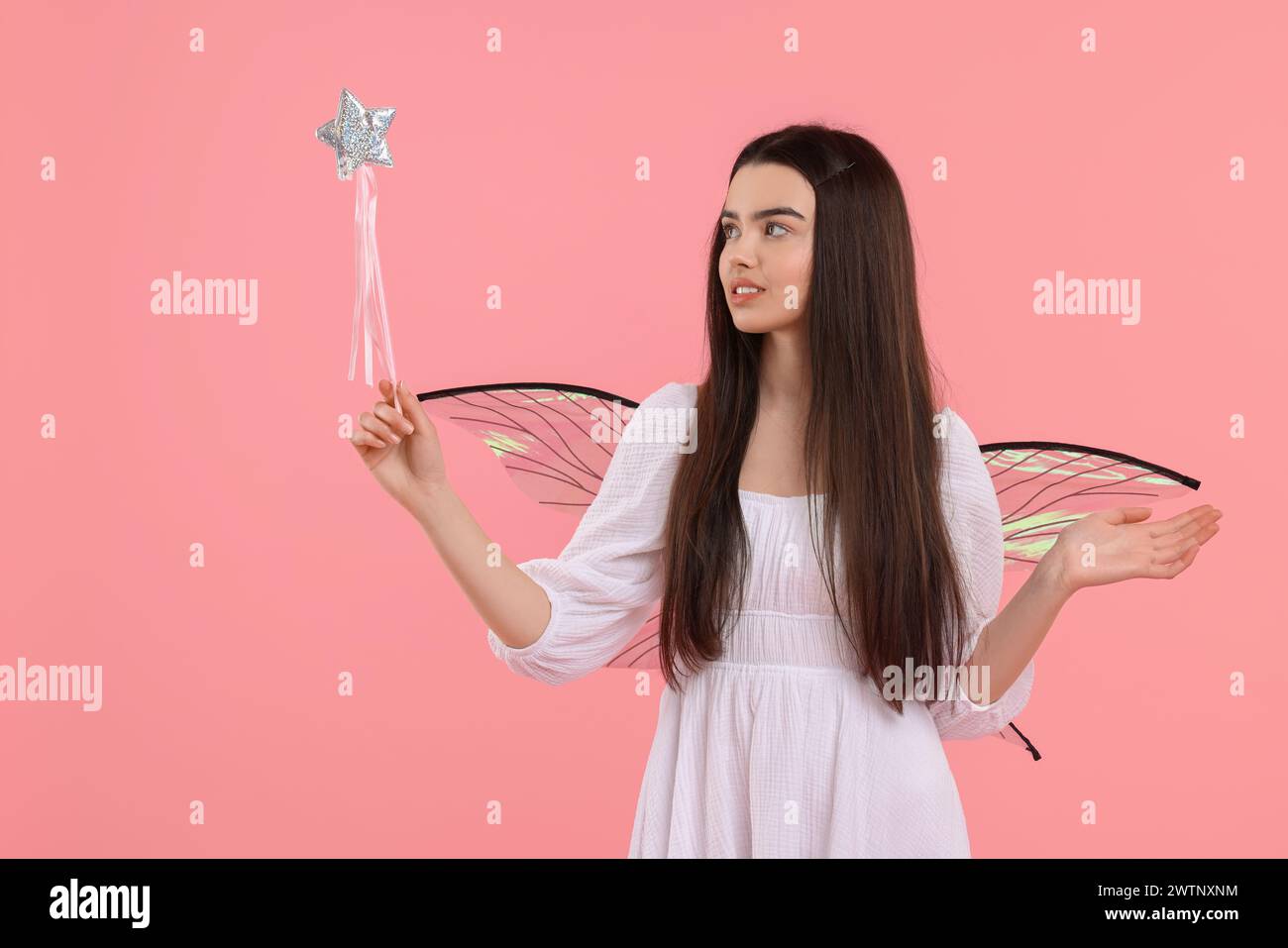 Beautiful girl in fairy costume with wings and magic wand on pink ...