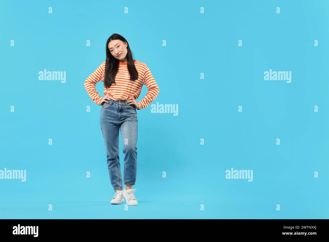 Full length portrait of cute woman on light blue background. Space for ...