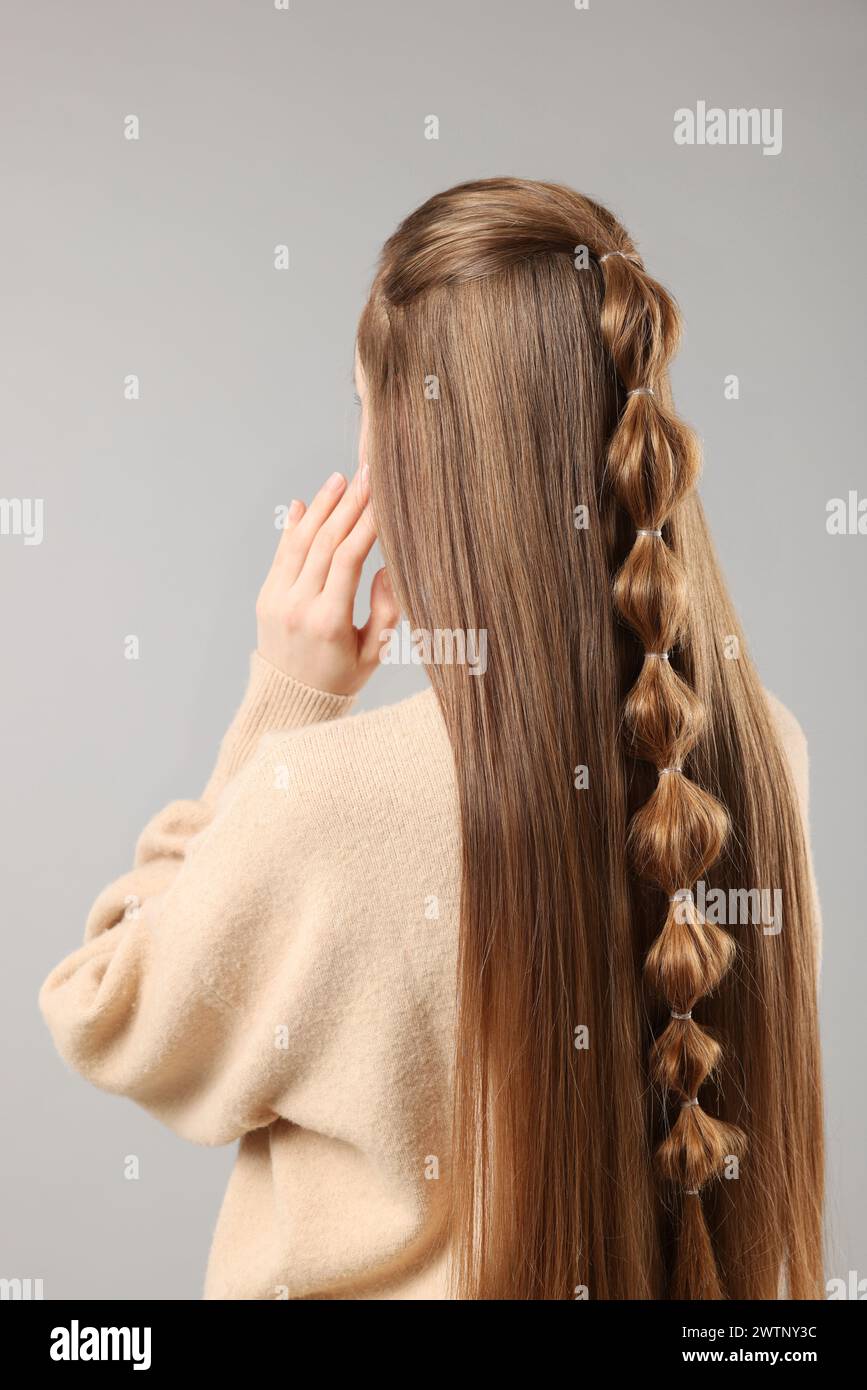 Woman with braided hair on grey background, back view Stock Photo - Alamy