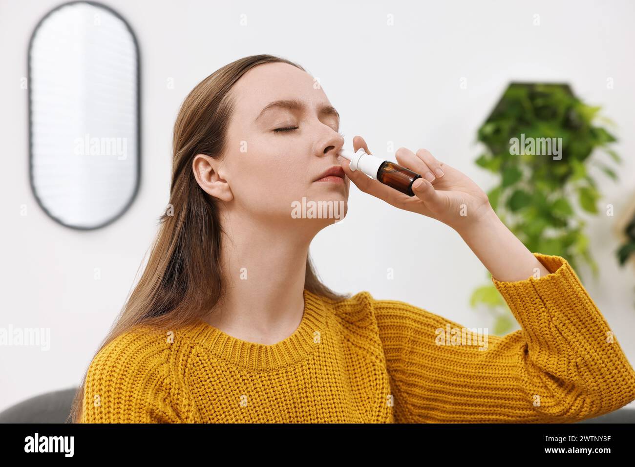 Medical drops. Young woman using nasal spray indoors Stock Photo - Alamy