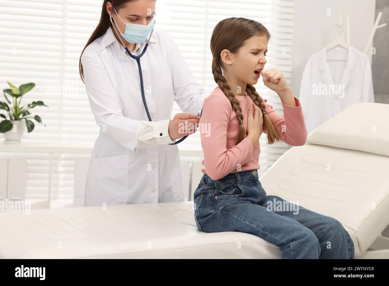 Doctor examining coughing girl in hospital. Cold symptoms Stock Photo ...