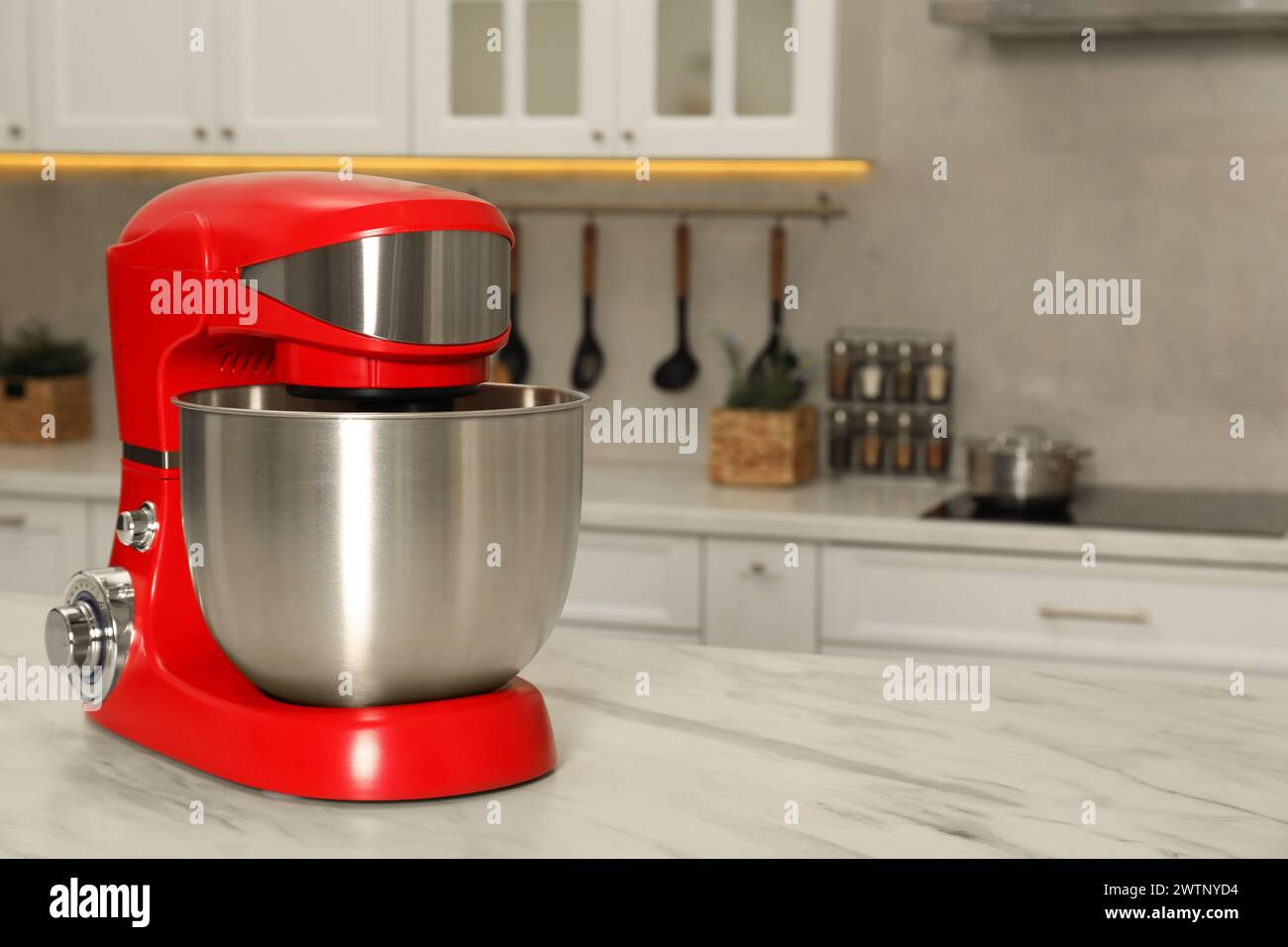 Modern red stand mixer on white marble table in kitchen, space for text ...