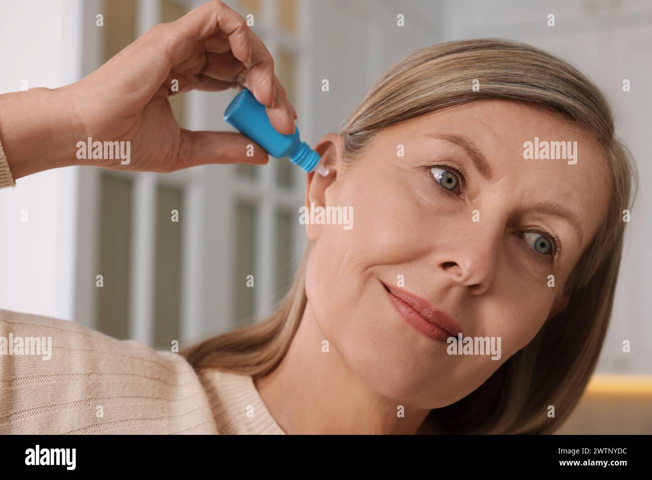 Woman applying medical ear drops at home Stock Photo - Alamy