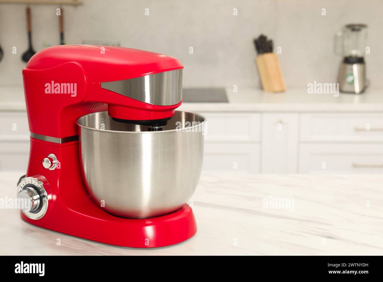 Modern red stand mixer on white marble table in kitchen, space for text ...