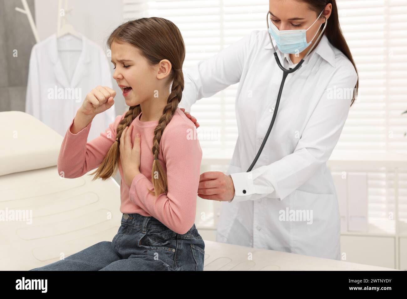 Doctor examining coughing girl in hospital. Cold symptoms Stock Photo ...