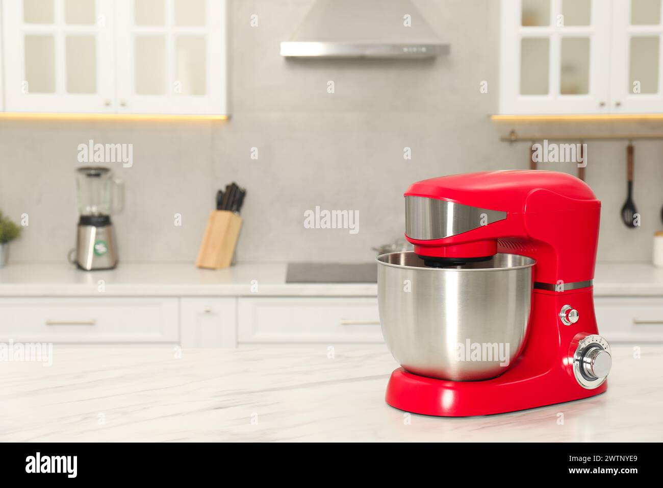 Modern red stand mixer on white marble table in kitchen, space for text ...