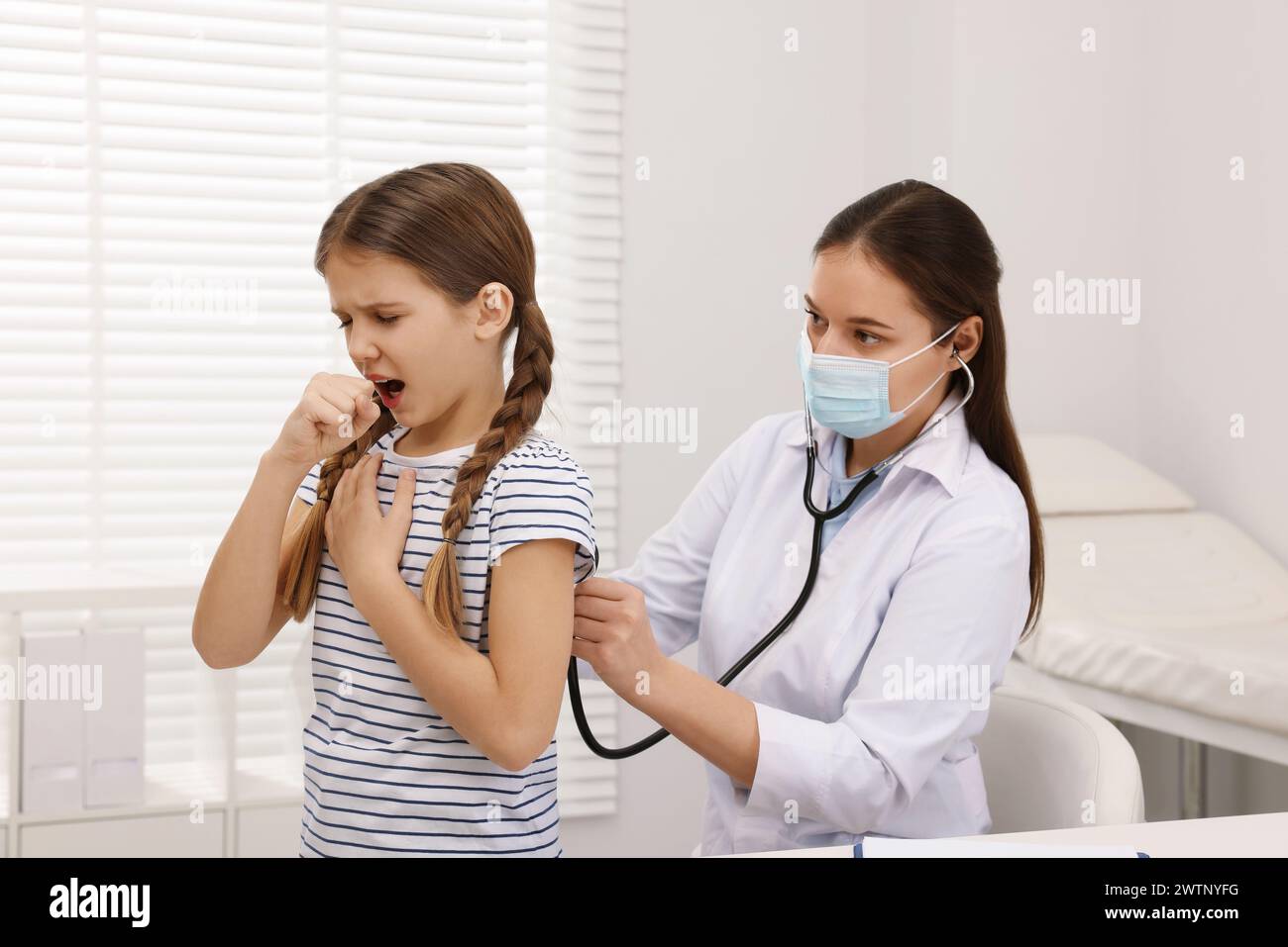 Doctor examining coughing girl in hospital. Cold symptoms Stock Photo ...