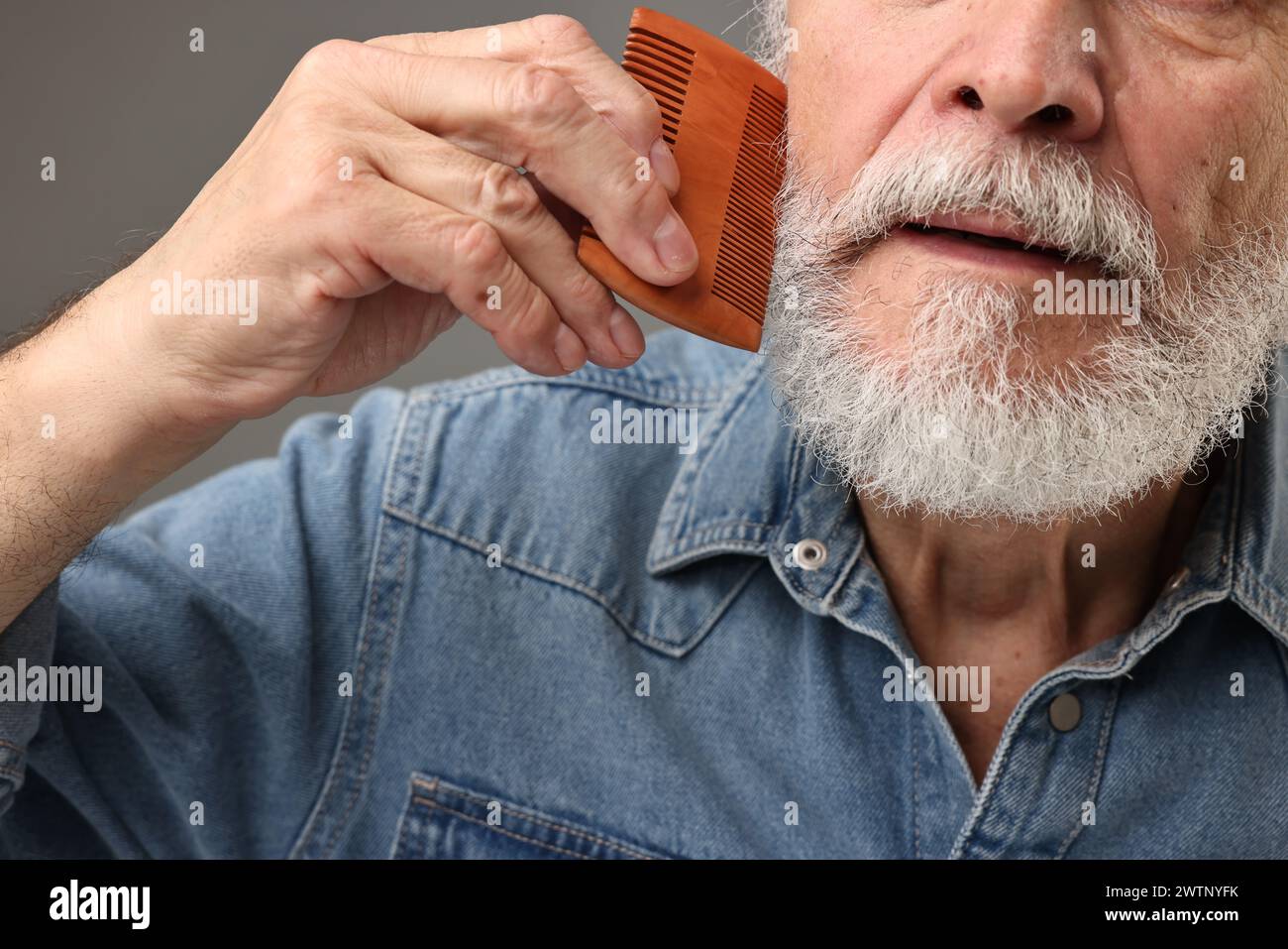 Man combing beard on grey background, closeup Stock Photo - Alamy