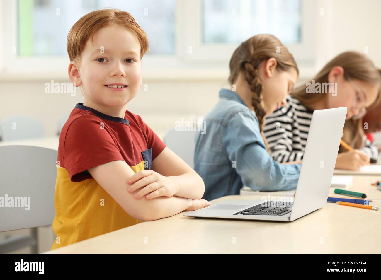 Smiling boy with his classmates studying in classroom at school Stock ...