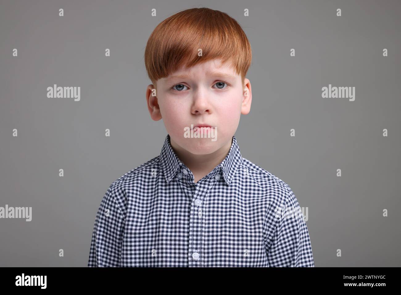 Portrait of sad little boy on grey background Stock Photo - Alamy