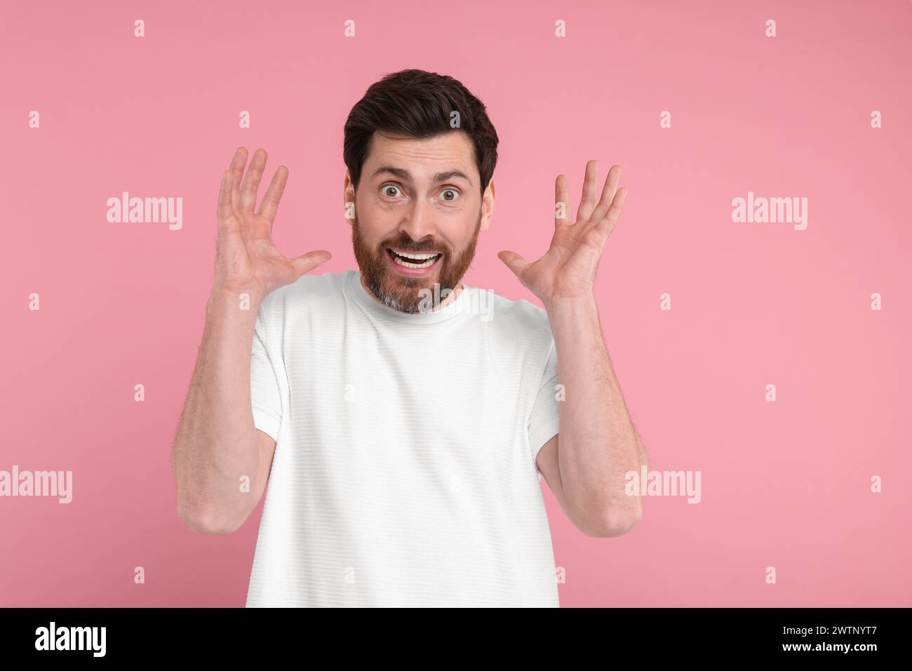 Portrait of surprised man on pink background Stock Photo - Alamy