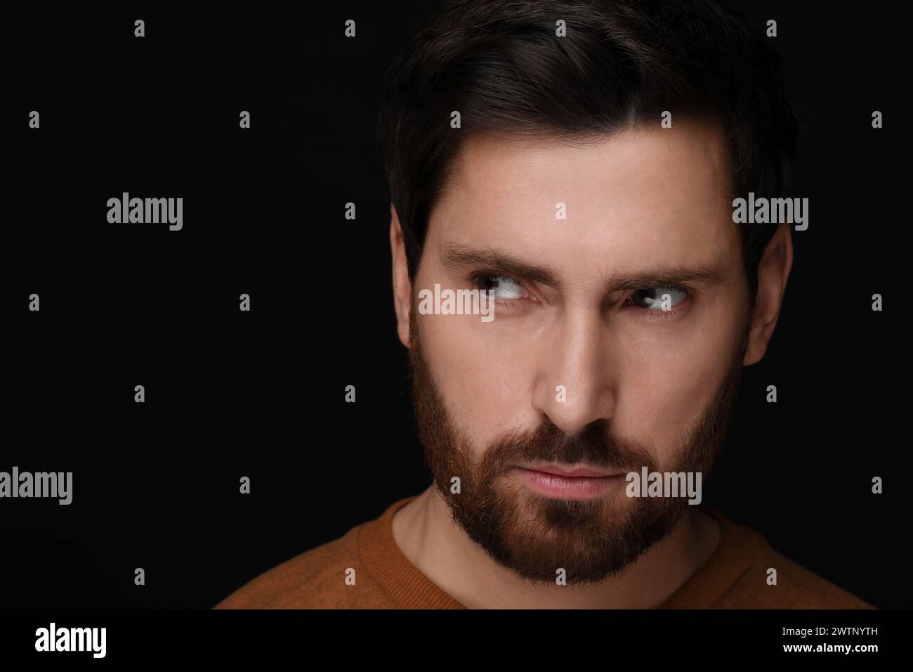 Evil eye. Man with scary eyes on black background, closeup and space ...