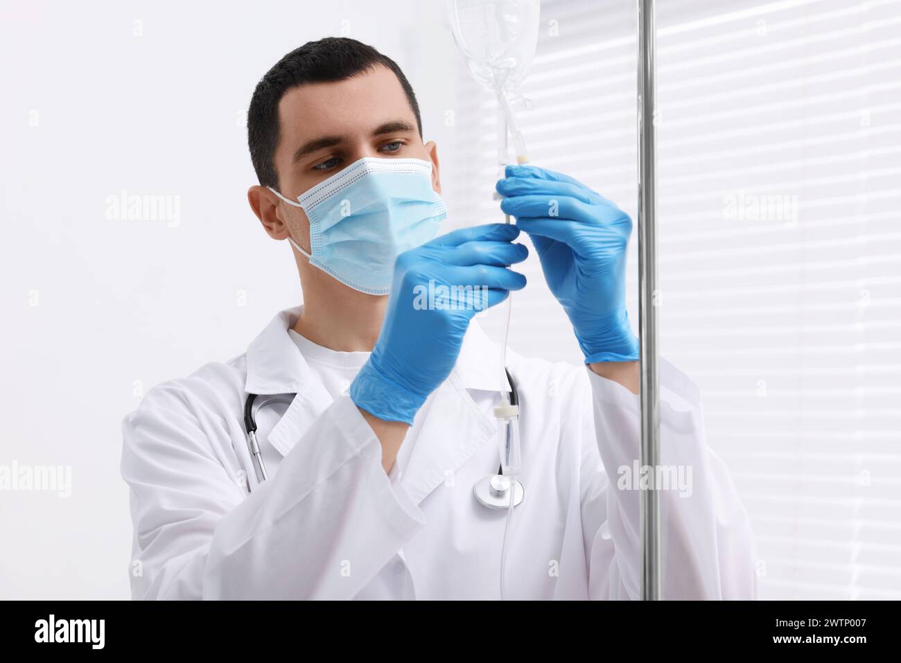 Doctor setting up IV drip in hospital Stock Photo - Alamy